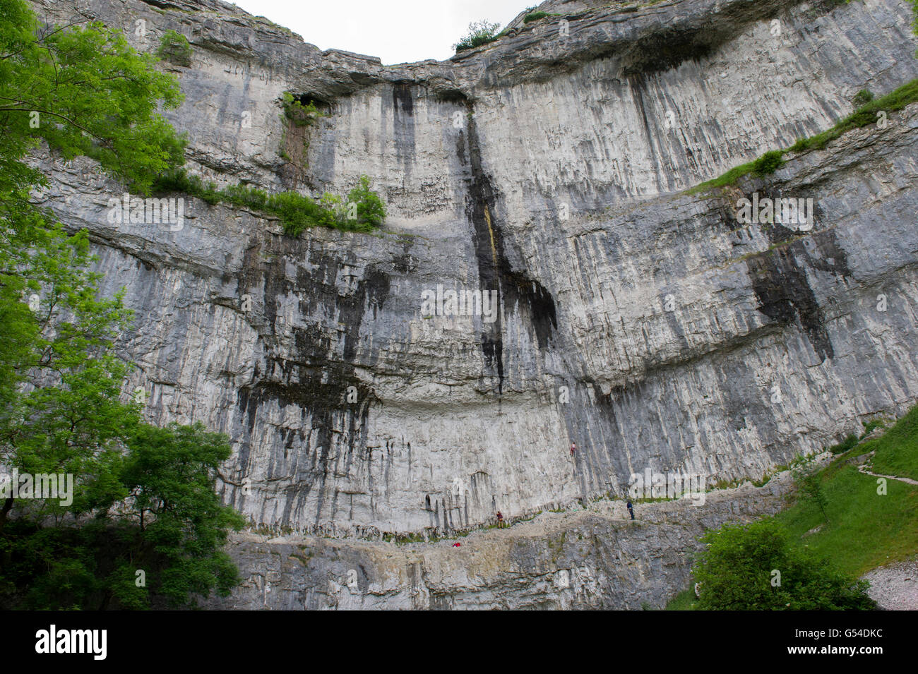Climbers tackling the huge rock wall of Malham Cove in the North ...