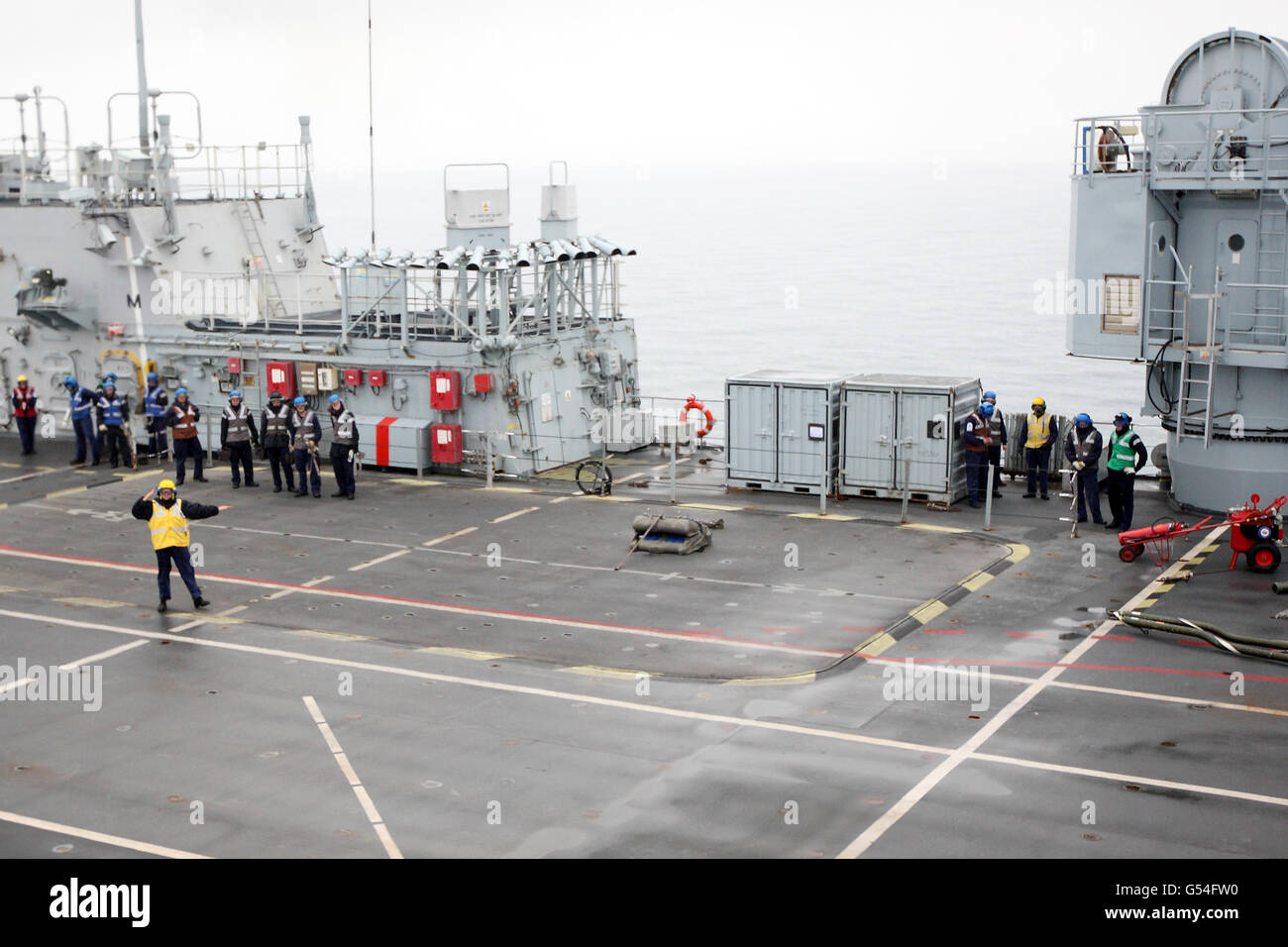 Ground crew guide in a Sea King Helicopter on to the flight deck of HMS ...