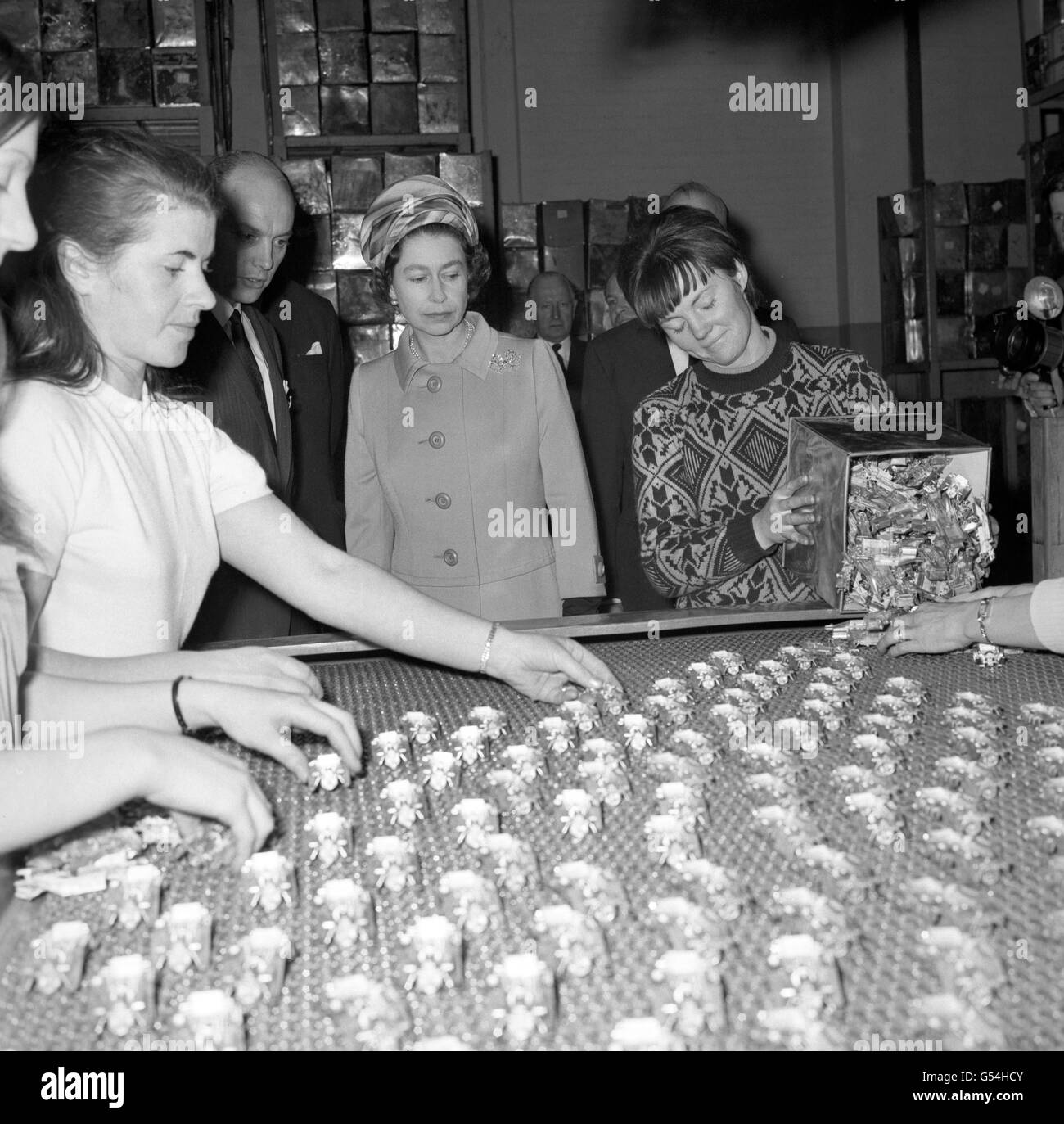 Queen Elizabeth II watches as miniature models are spread on a conveyor ...