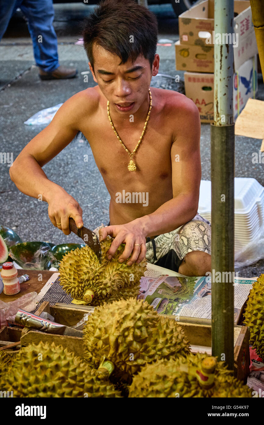 A young man prepares durian for sales at his stall on Chun Yeung Street ...