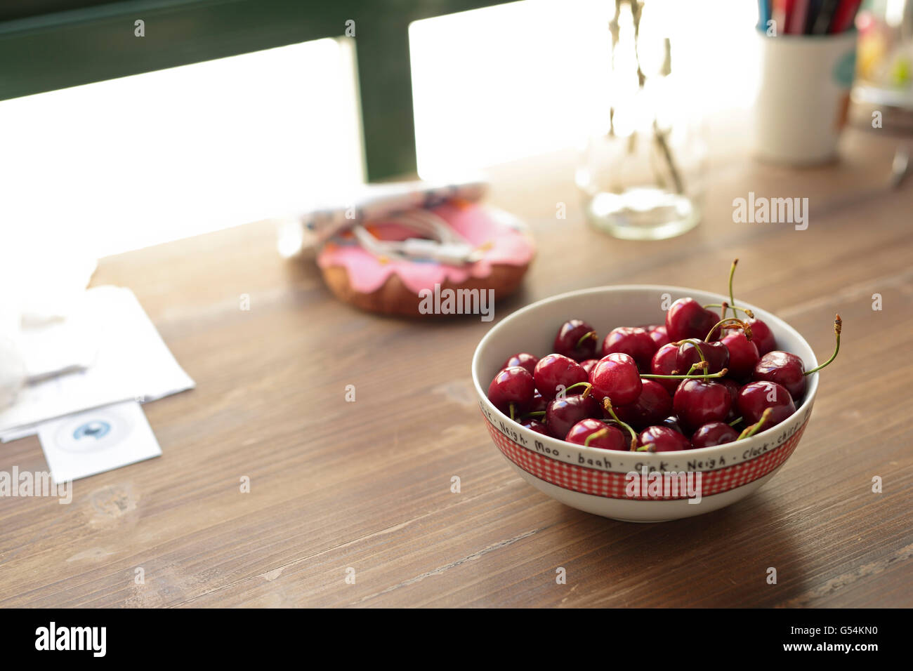 Cherries ripen a ceramic bowl on a table Stock Photo - Alamy