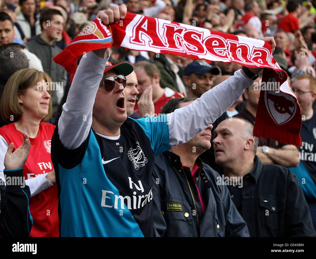 Arsenal fans show support for their team in the stands Stock Photo - Alamy