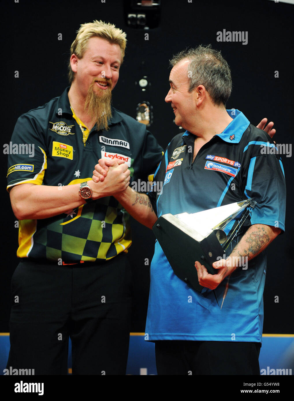 Simon Whitlock (left) congratulates Phil Taylor, following Taylor's win ...
