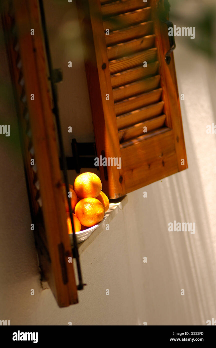 Oranges on window ledge with shutters open and dappled light Stock ...