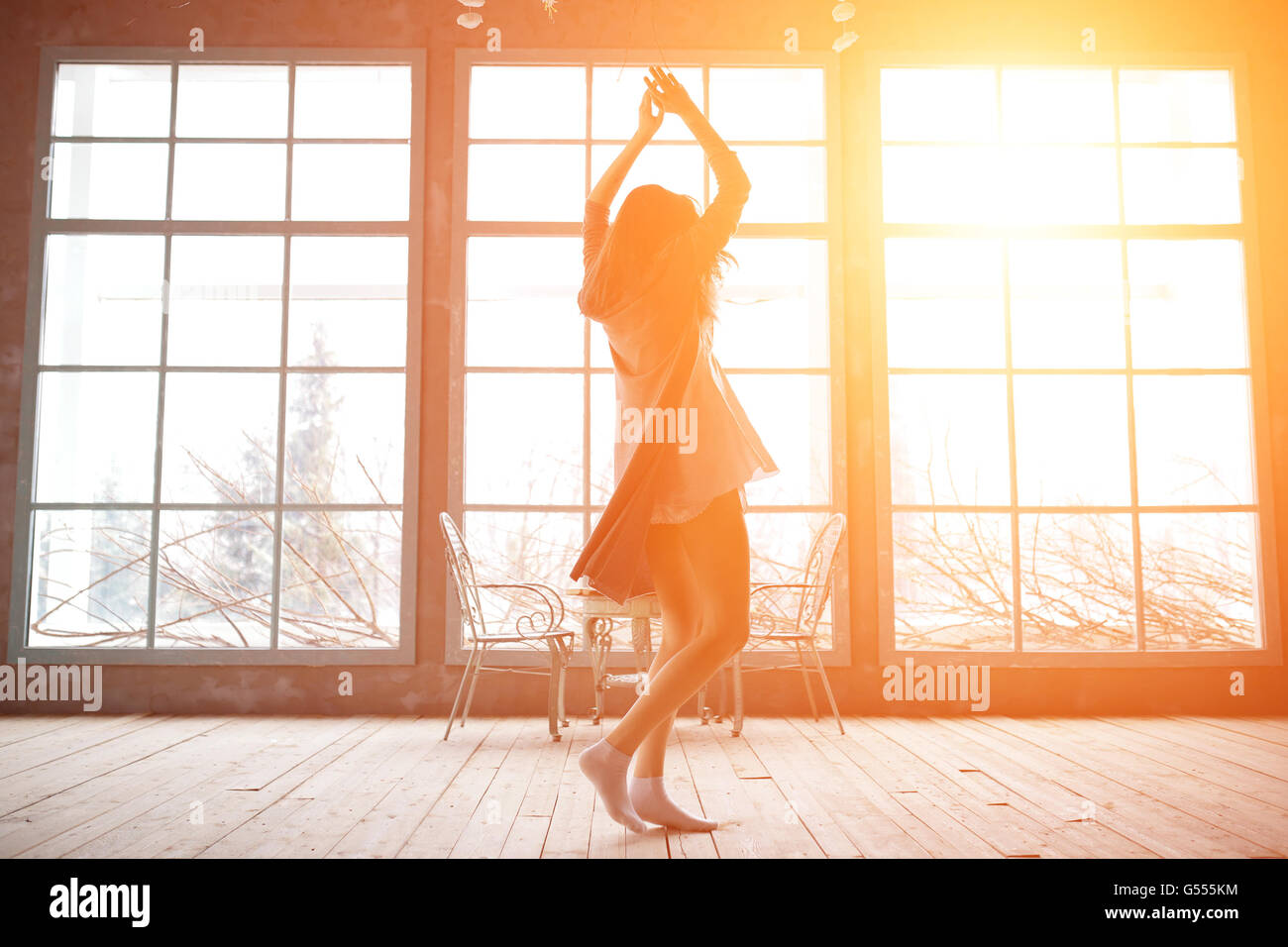 Attractive young woman dancing near huge windows Stock Photo - Alamy