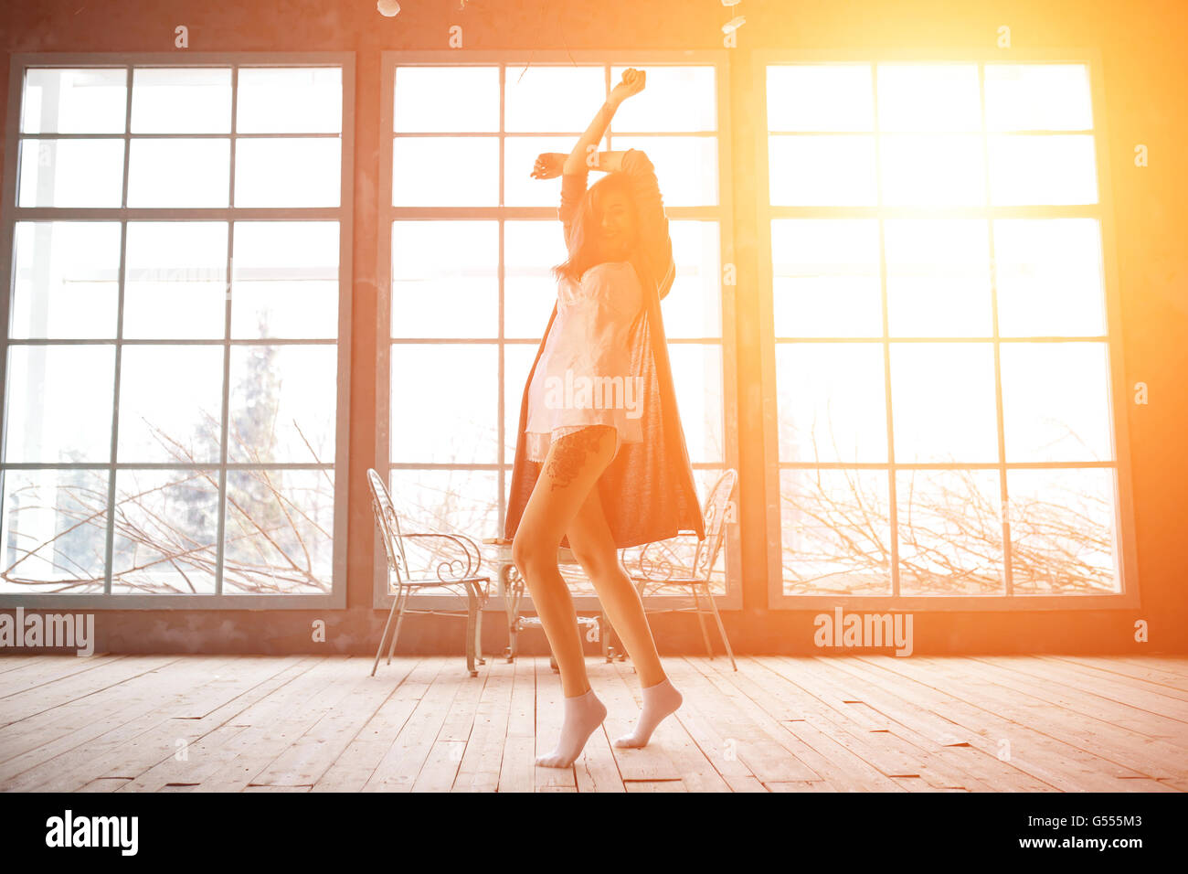 Attractive young woman dancing near huge windows Stock Photo - Alamy