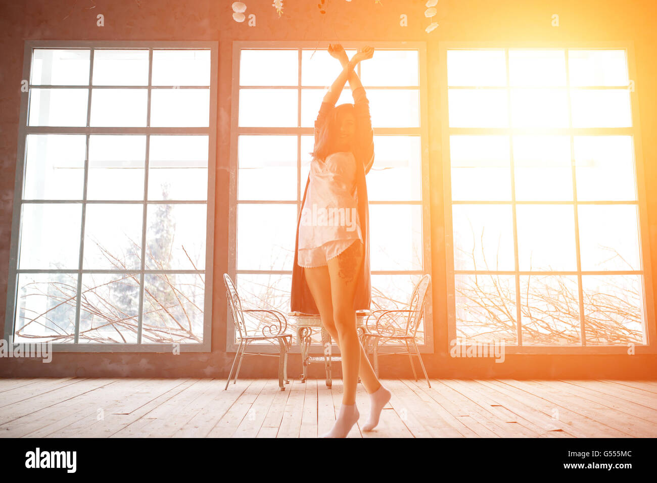 Attractive young woman dancing near huge windows Stock Photo - Alamy