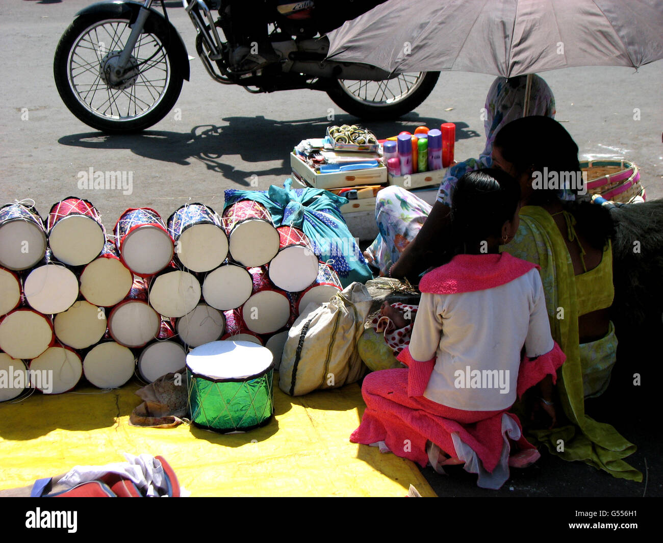 A poor woman and her daughter selling hand made drums in her streetside ...