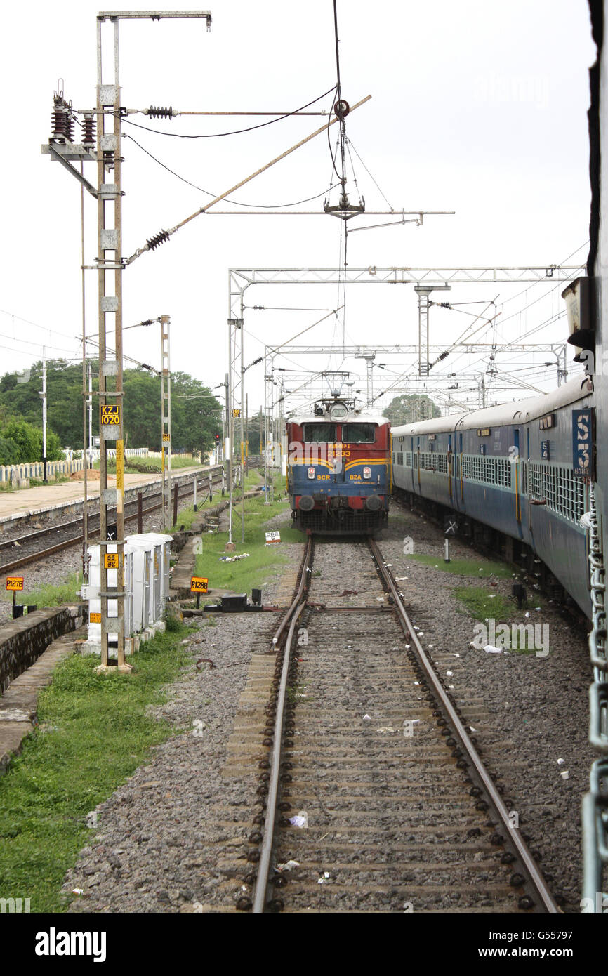 A locomotive approaching a train on a railway track Stock Photo - Alamy