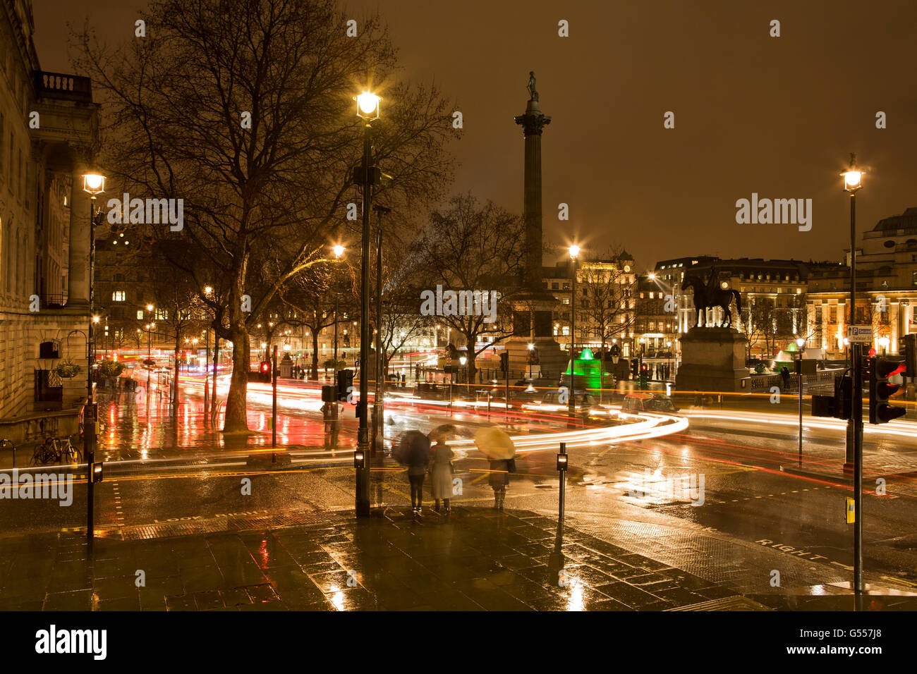 London, England, Trafalgar Square at night in rain, car light streaks ...