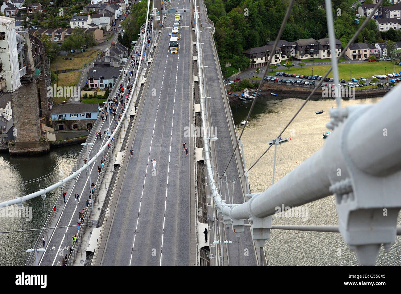 Torchbearer Andrew Ball from Saltash, runs over the Tamar Bridge to ...