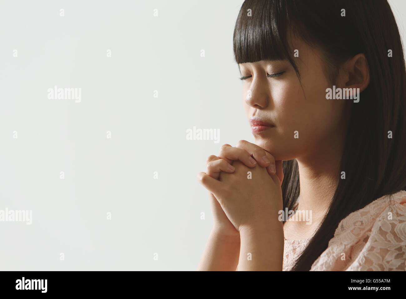 Woman holding hands up praying hi-res stock photography and images - Alamy