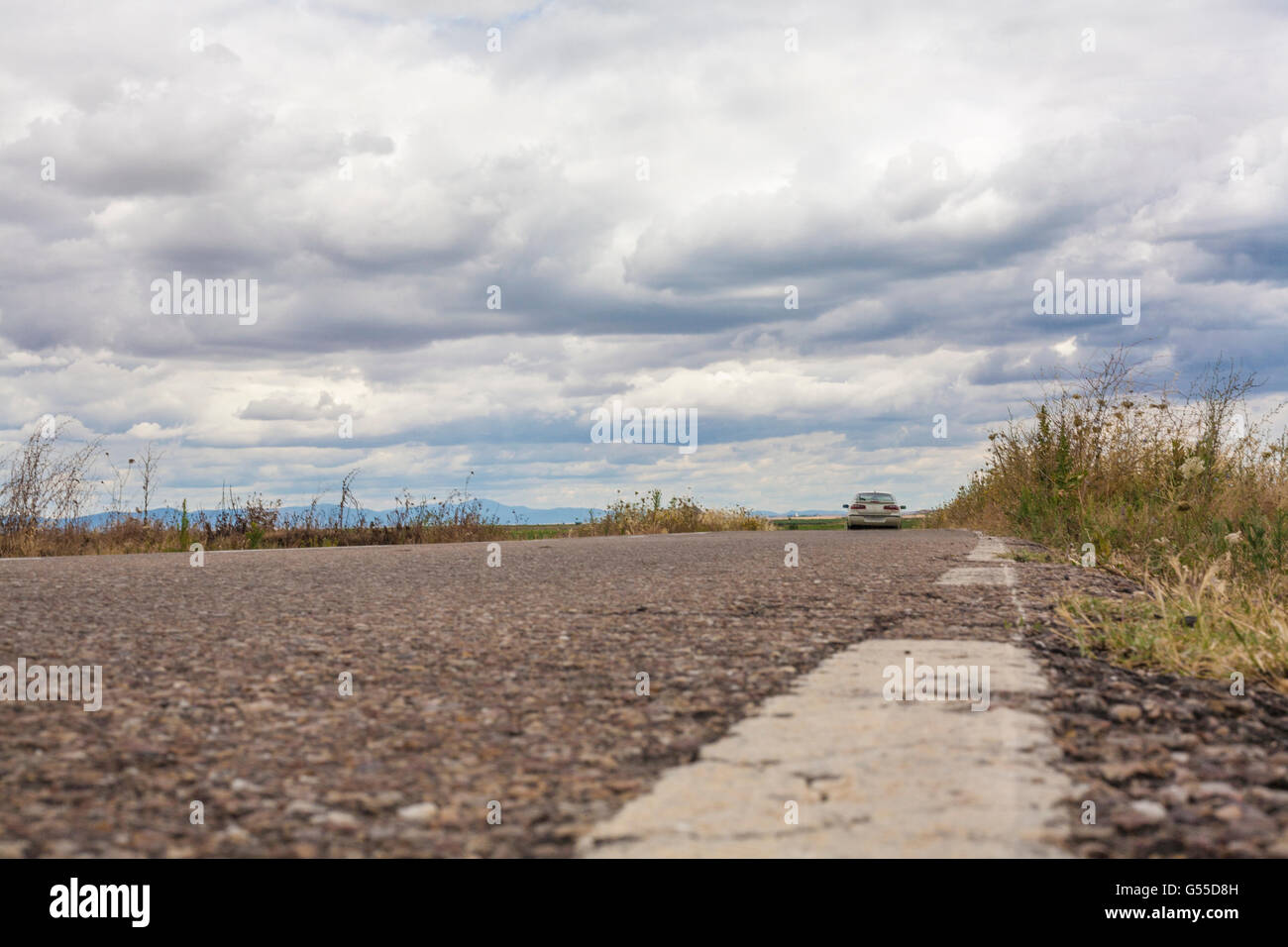 Lonely car traveling down by the green meadows of Vegas Altas del ...