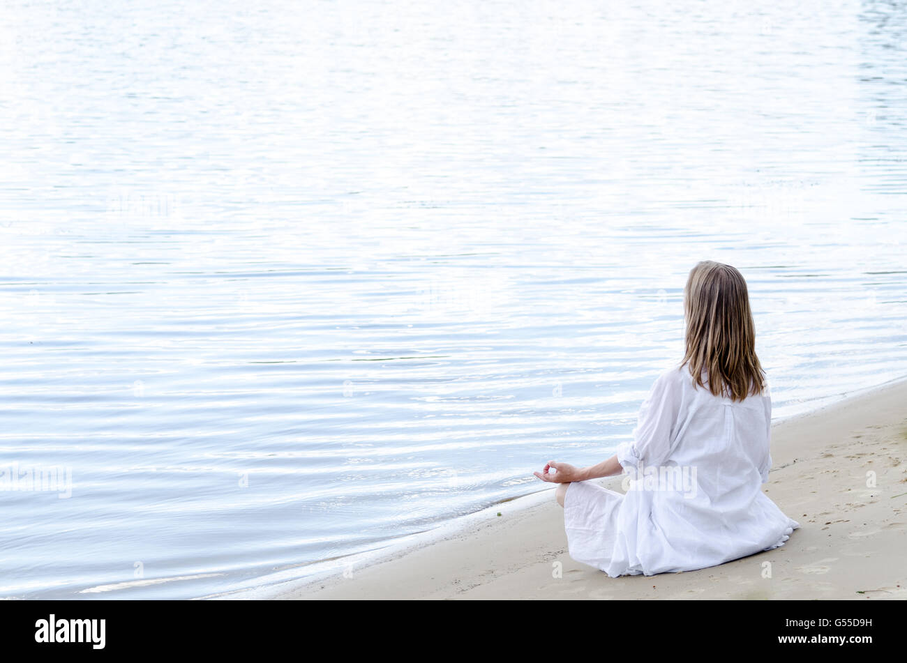 Woman meditating at the sea Stock Photo - Alamy