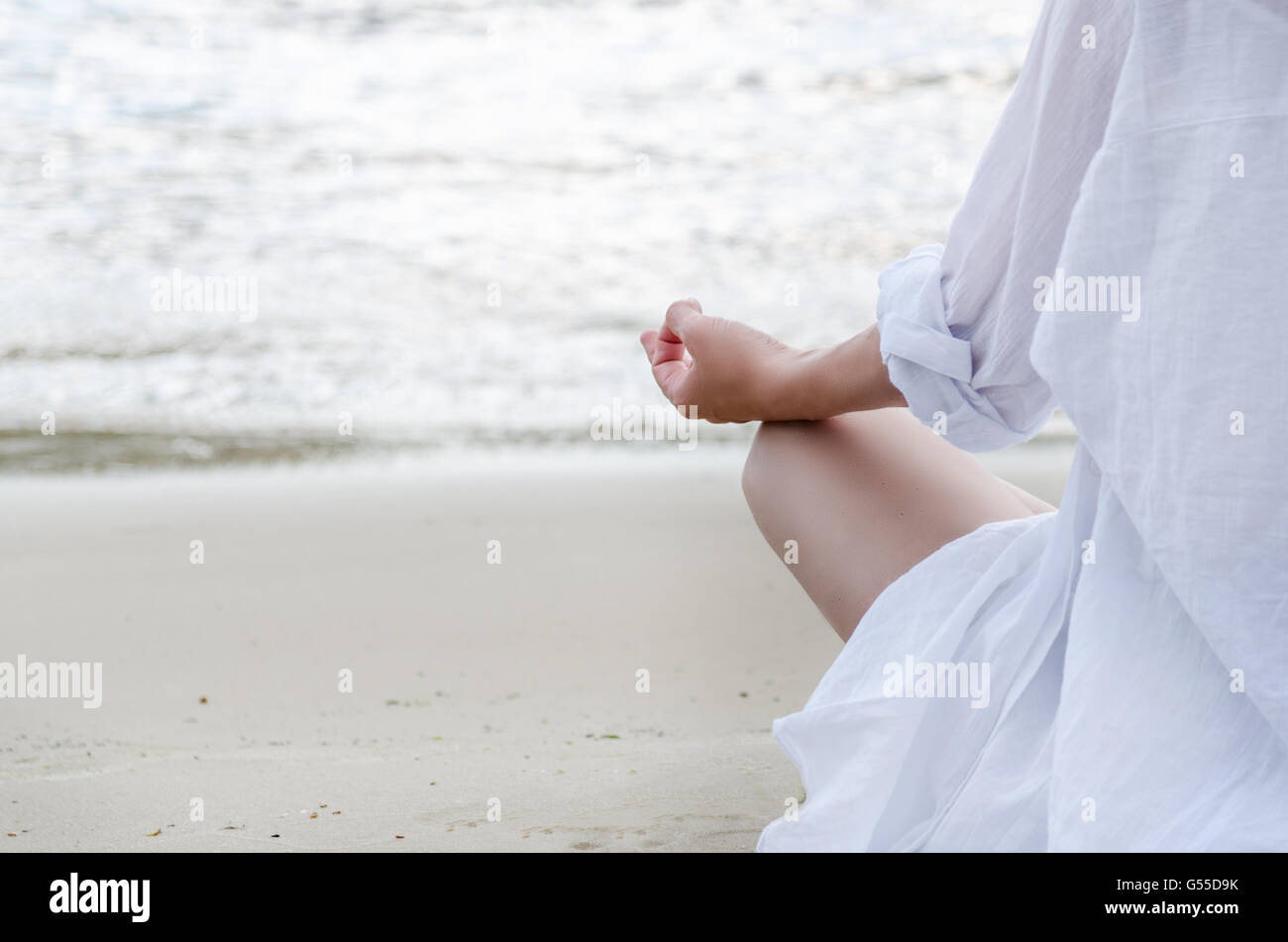 Woman meditating at the sea Stock Photo - Alamy