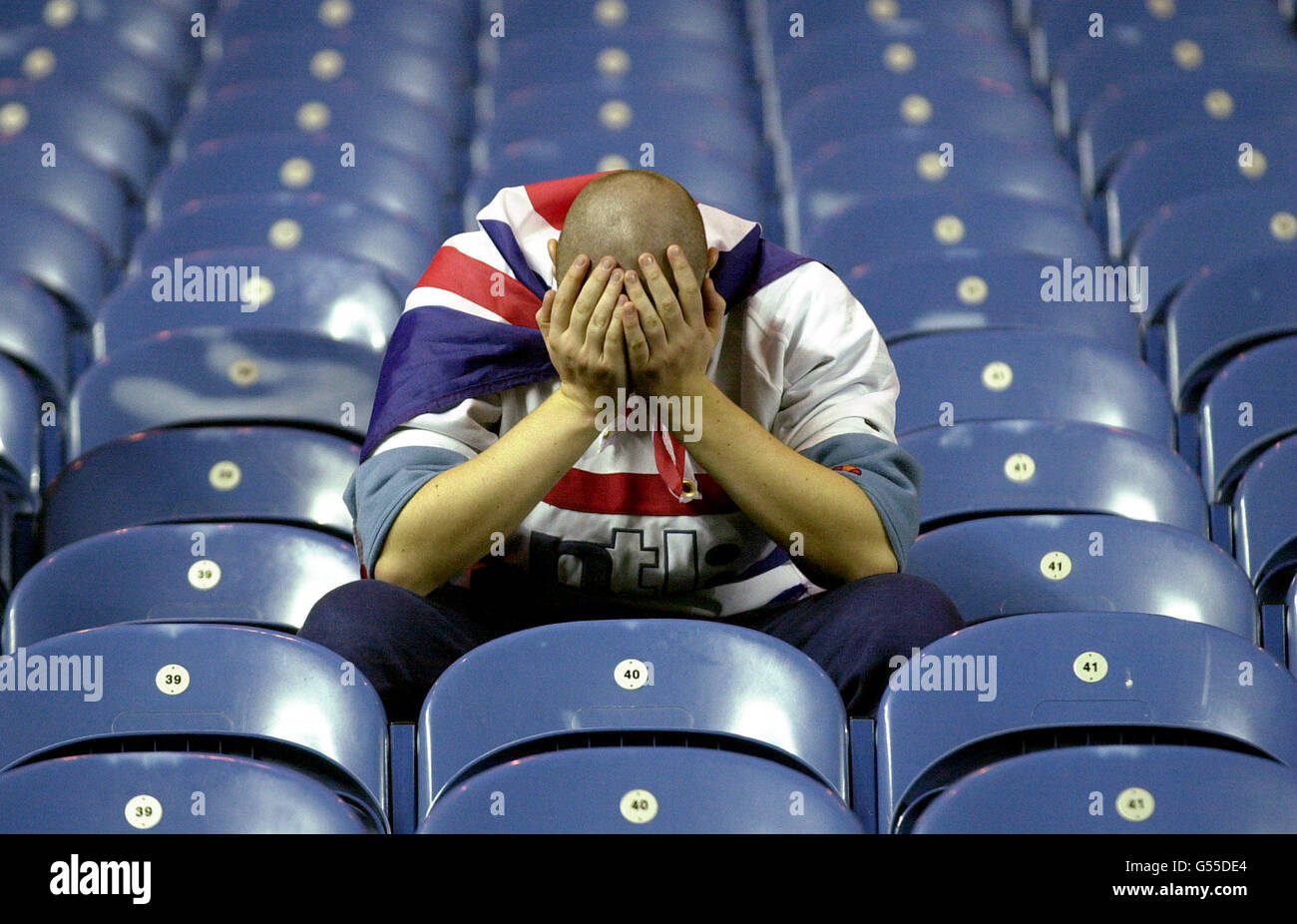 A dejected Rangers fan remains amongst empty seats as they are dumped ...