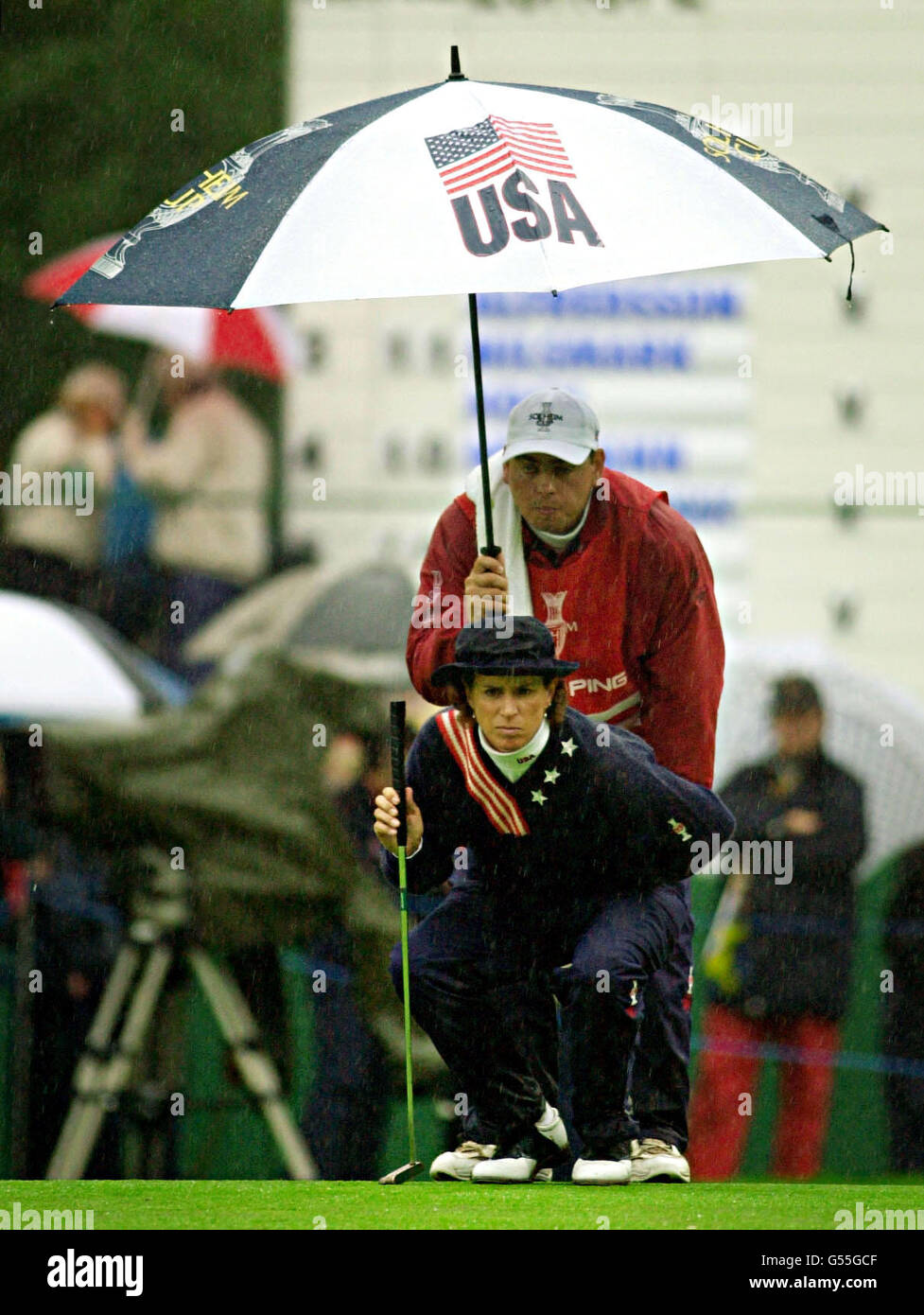 The USA's Juli Inkster takes shelter under her caddy's umbrella as she ...