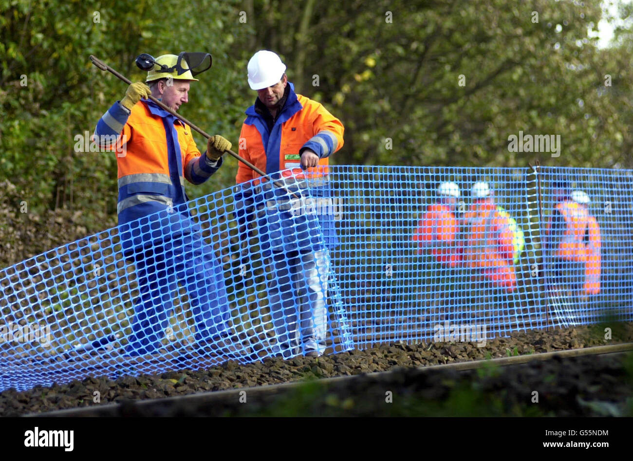 Railway workers seal off the area around the landslip at Polmont ...