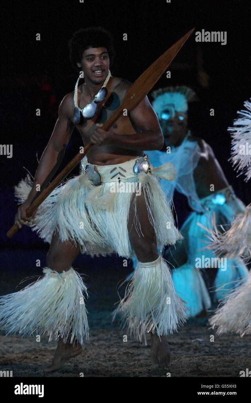 A traditional dancer from the Cook Islands performs in the rain during ...