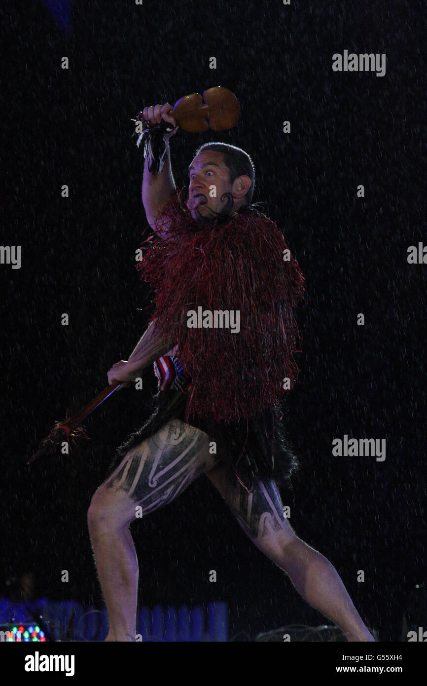 A Maori performer from New Zealand performs in the rain during the ...