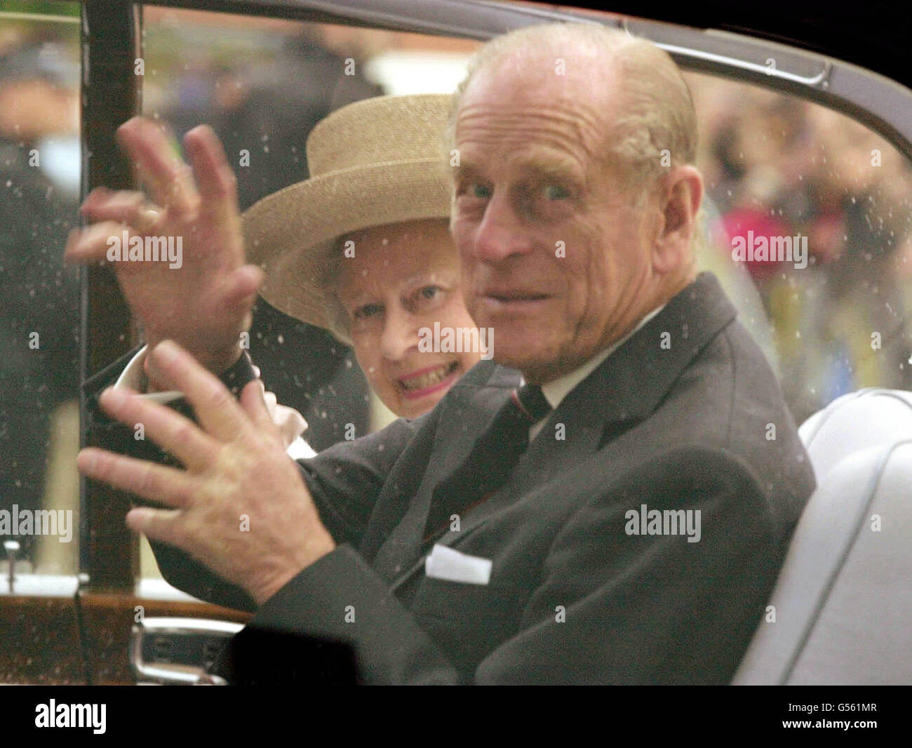 Britain's Queen Elizabeth II and the Duke of Edinburgh wave to crowds ...