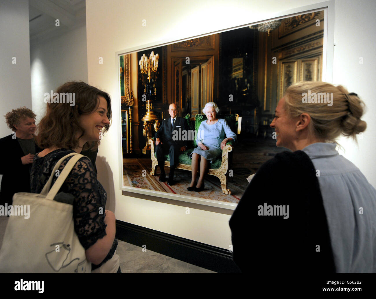 Two women share a laugh while viewing Queen Elizabeth II and The Duke ...