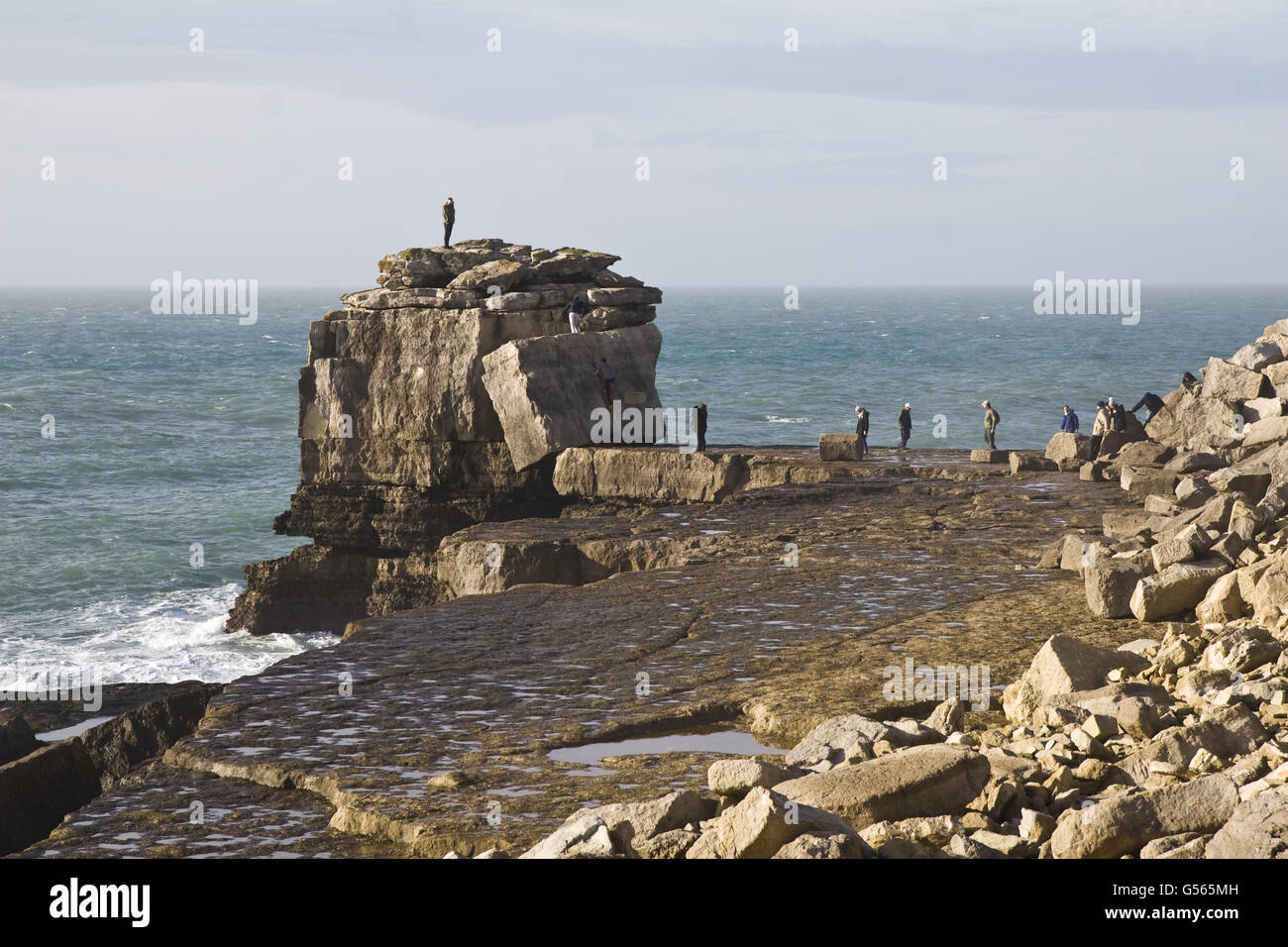 People climbing on large rock at coastal headland, Pulpit Rock ...