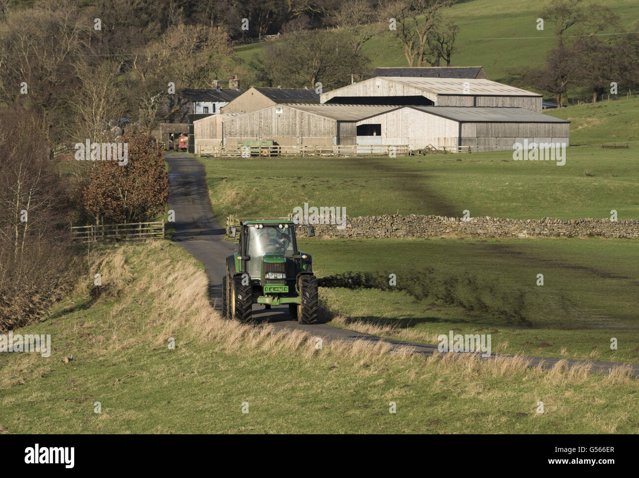 John Deere tractor with slurry tanker, spreading slurry on field from ...