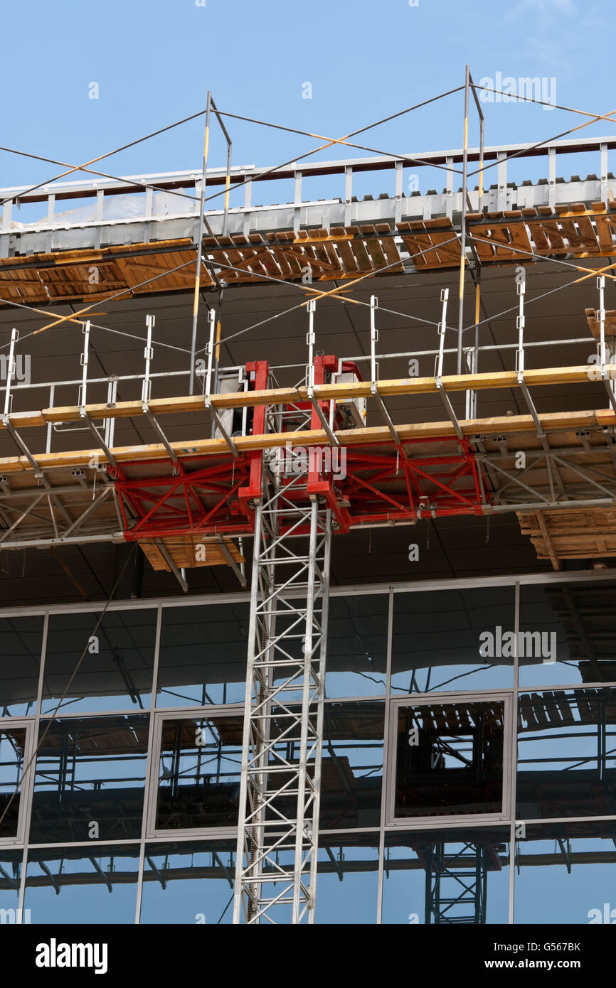 Modern buildings under construction. Metal scaffolding with wooden ...