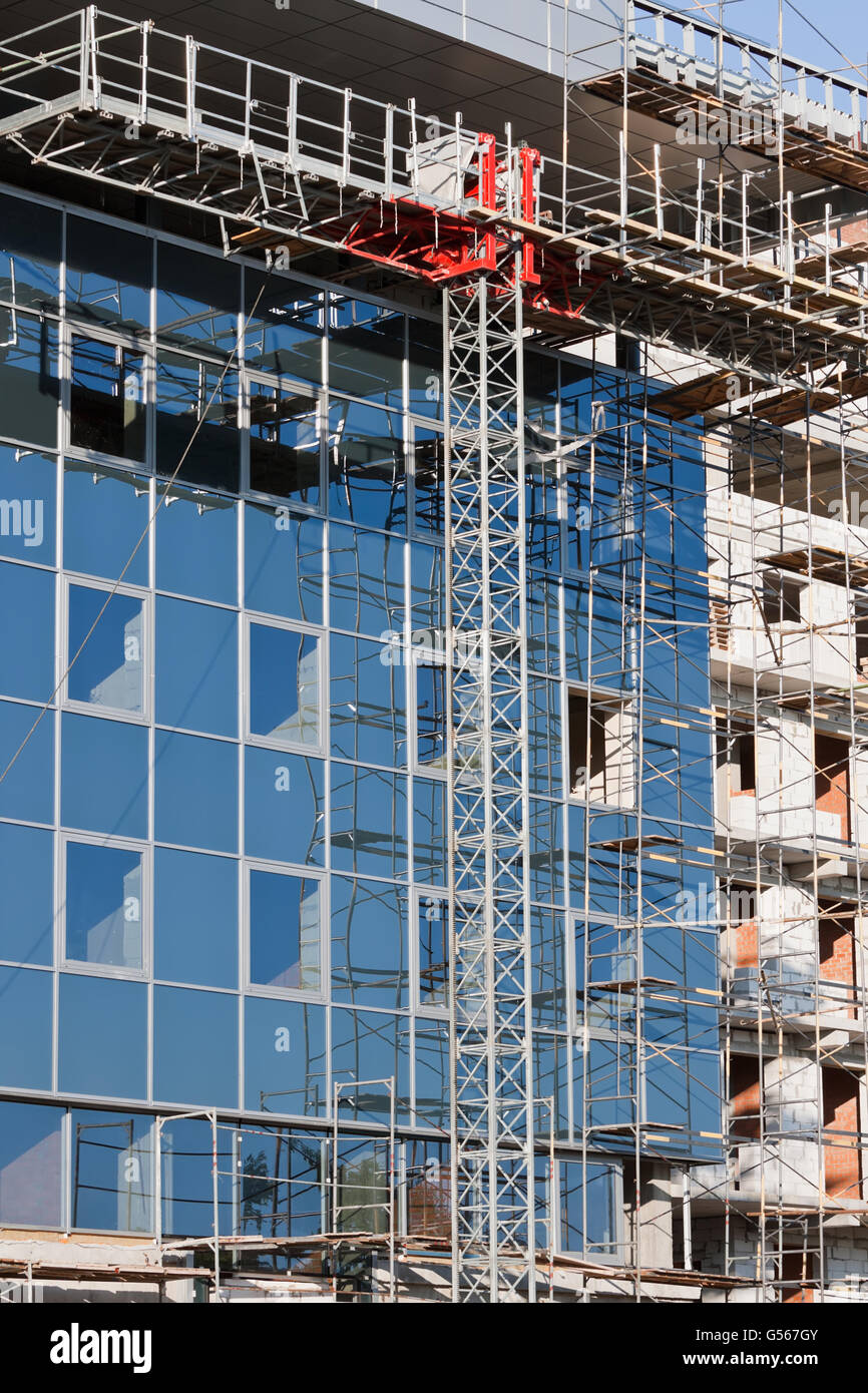 Modern buildings under construction. Metal scaffolding with wooden ...