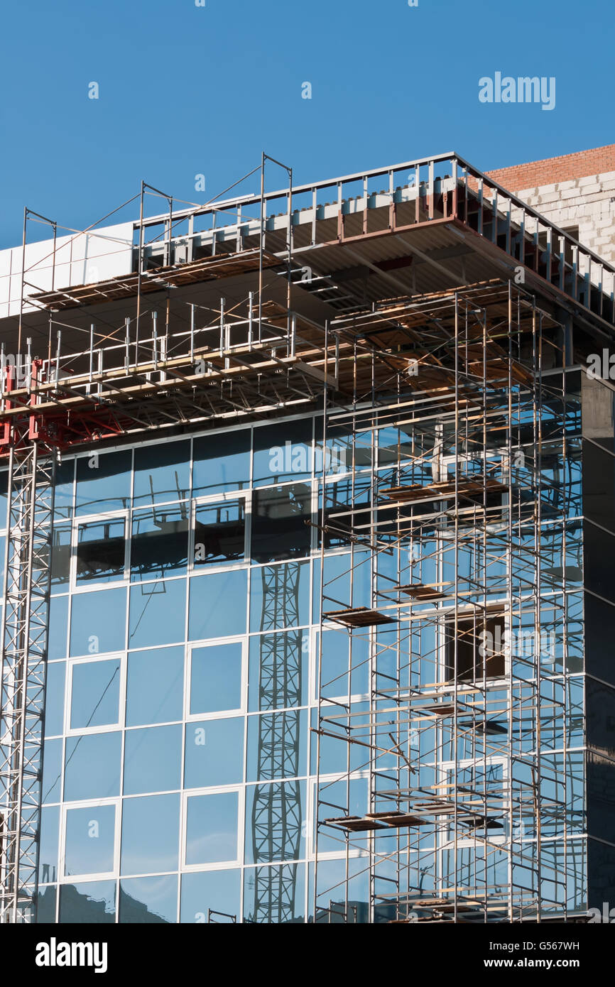 Modern buildings under construction. Metal scaffolding with wooden ...