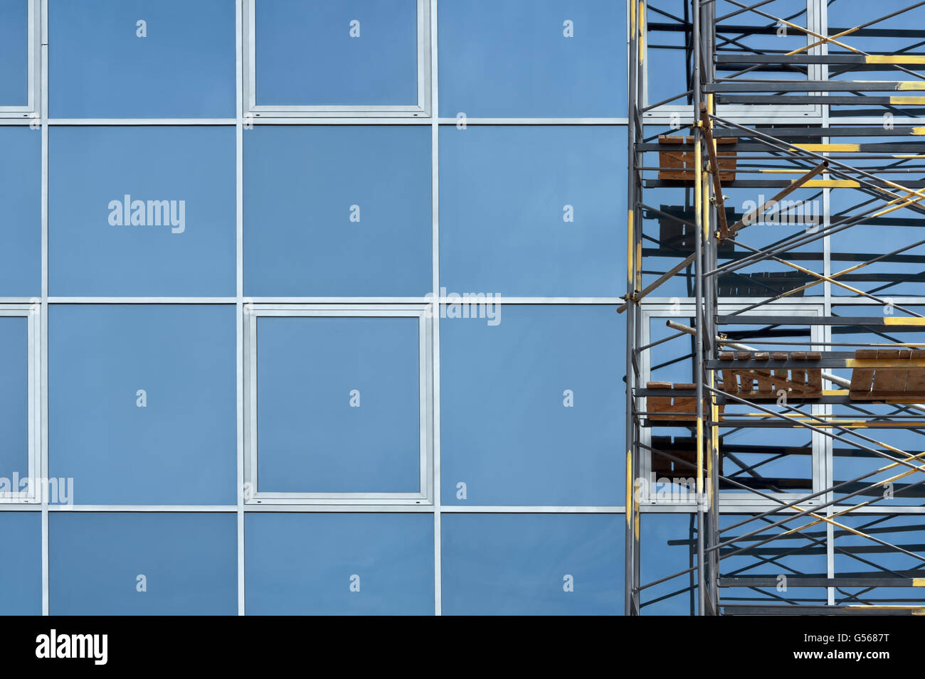 Reflection of a construction site in windows of modern office building ...