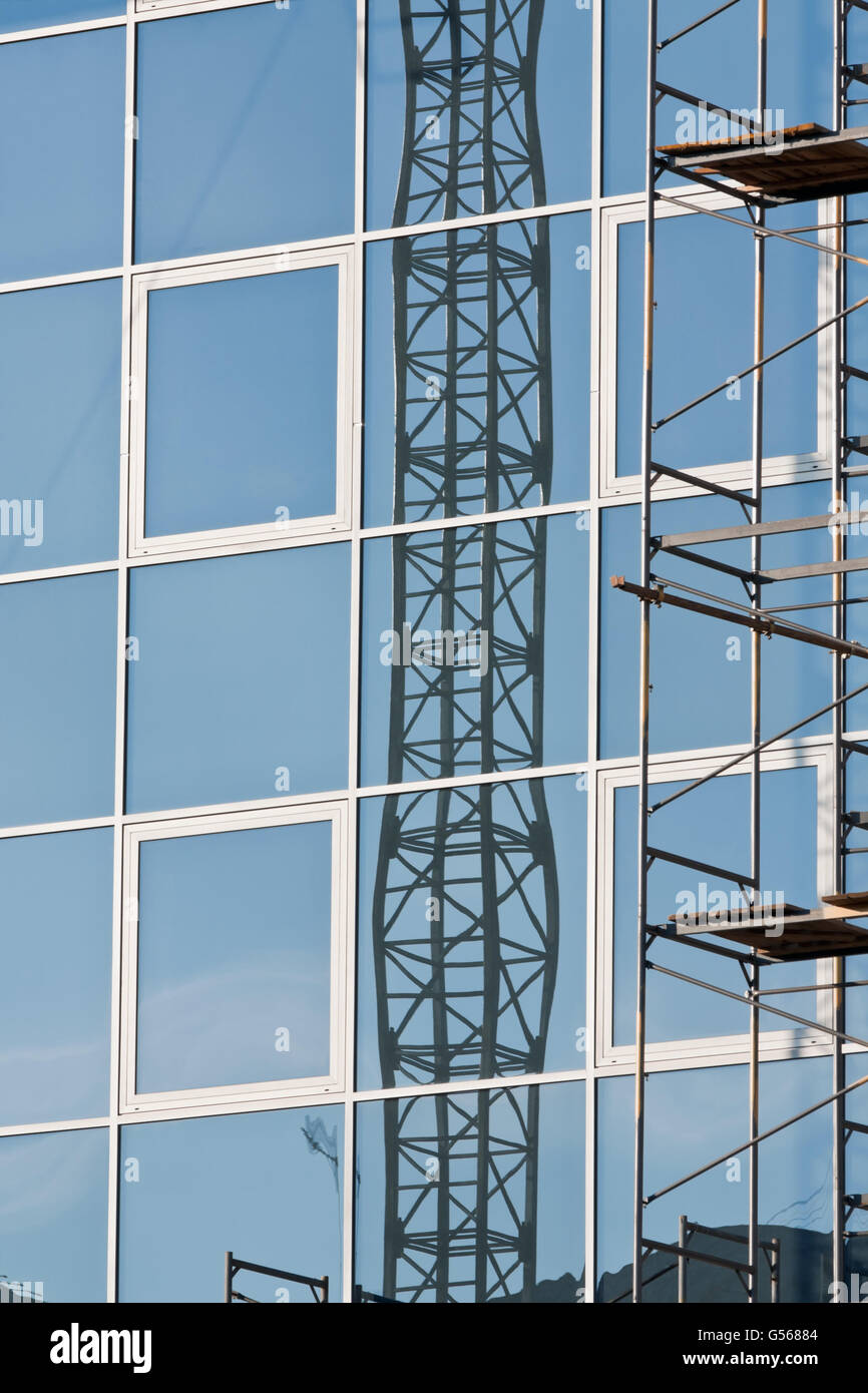 Reflection of a construction site in windows of modern office building ...