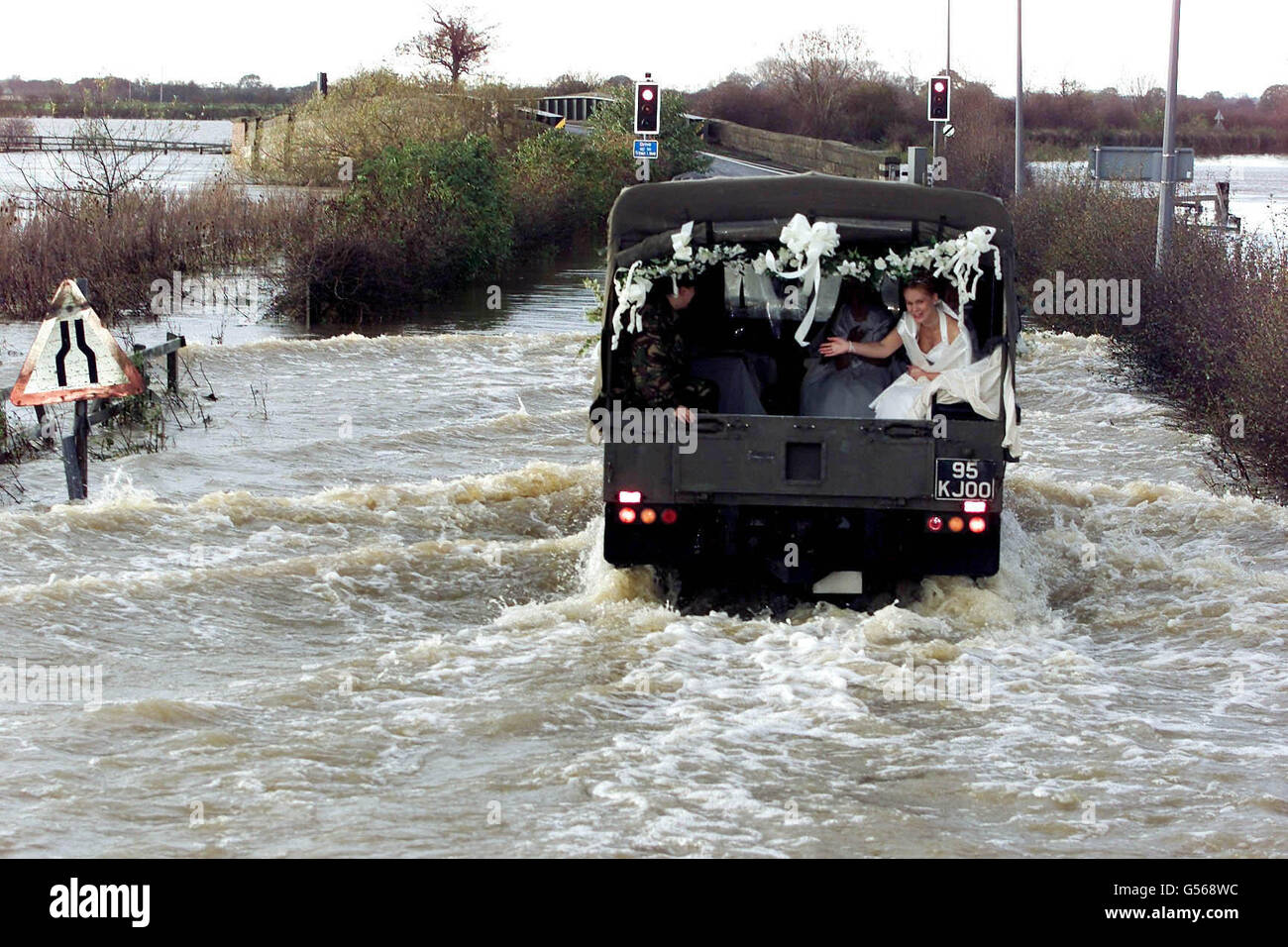 Bride Anita Hudson, 26, with her bridesmaids and parents, is helped by ...