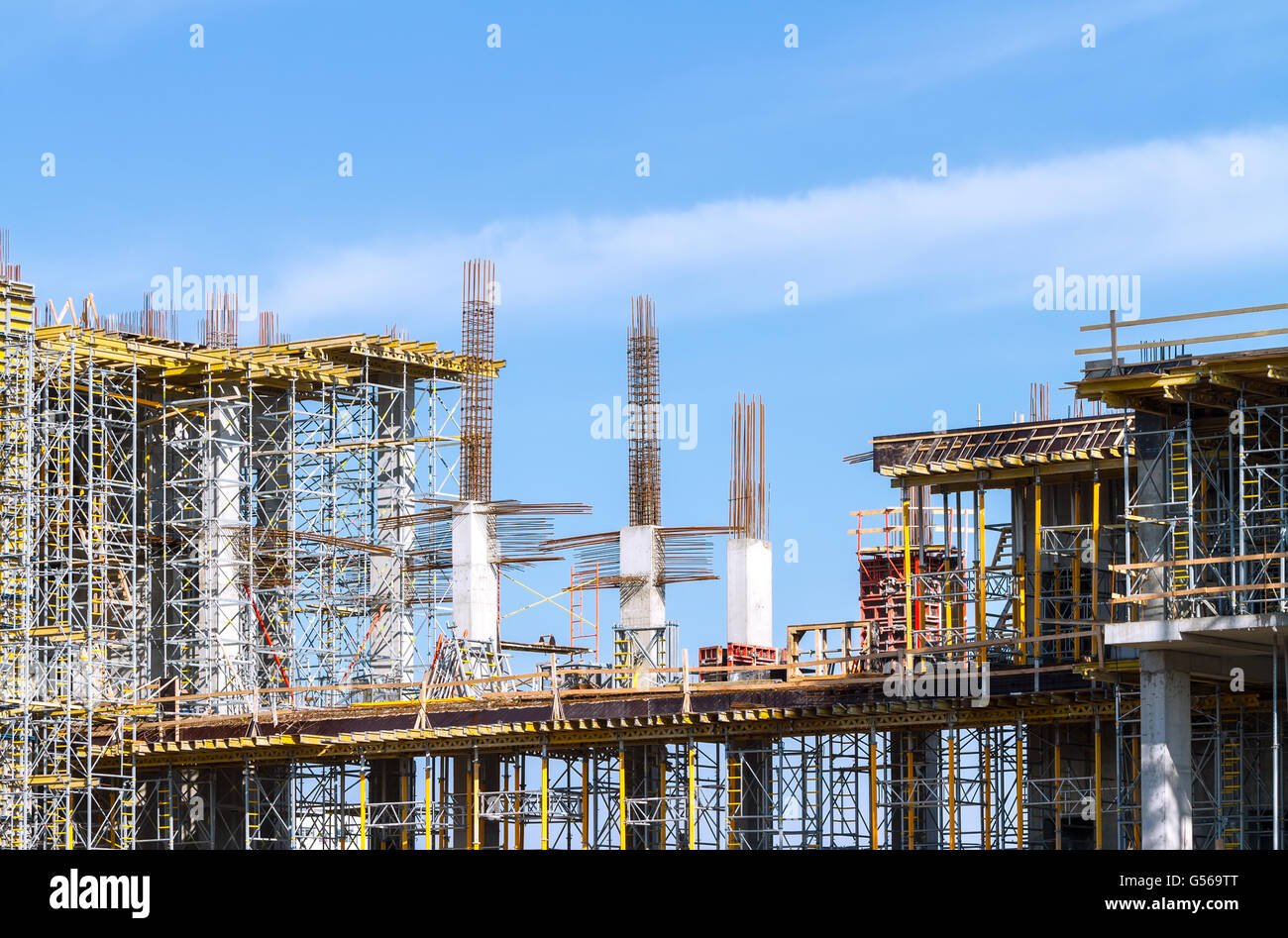 Incomplete building under construction with scaffolding and reinforced ...
