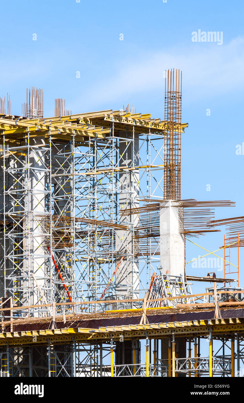 Incomplete building under construction with scaffolding and reinforced ...