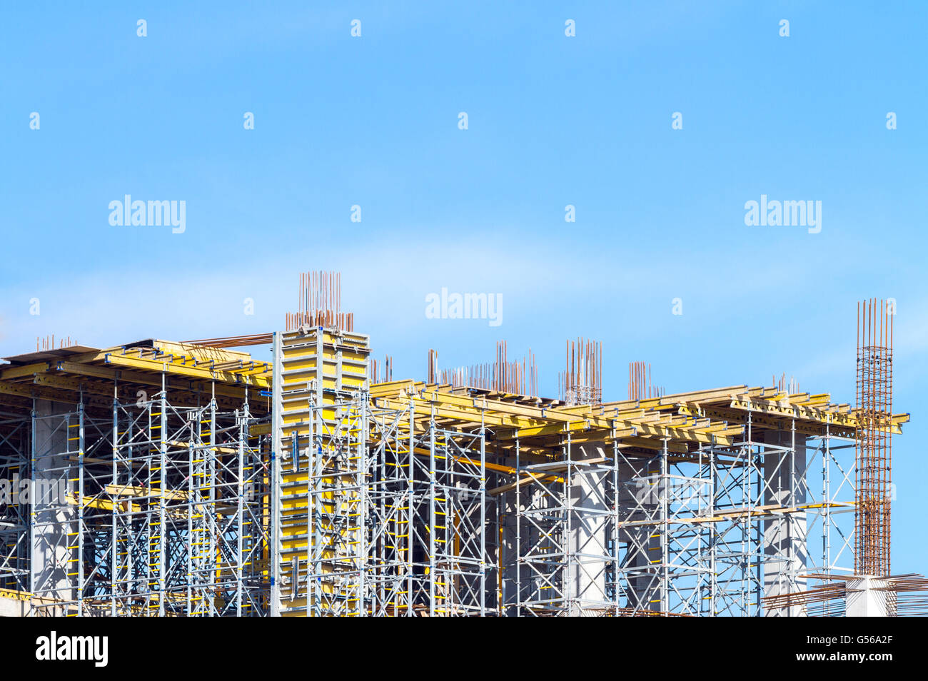 Incomplete building under construction with scaffolding and reinforced ...