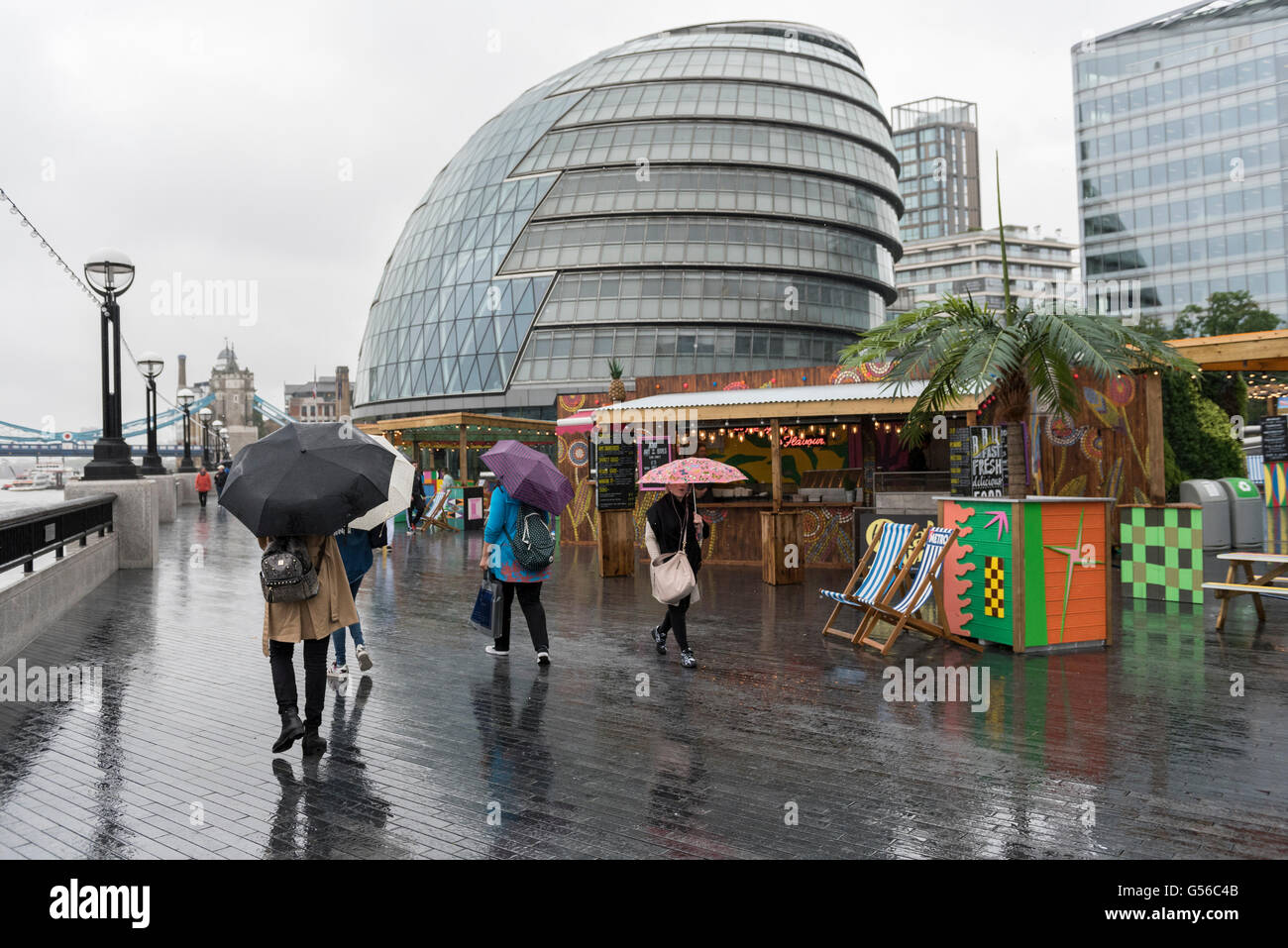 London, UK. 20 June 2016. Tourists walk in the heavy rain pouring down ...