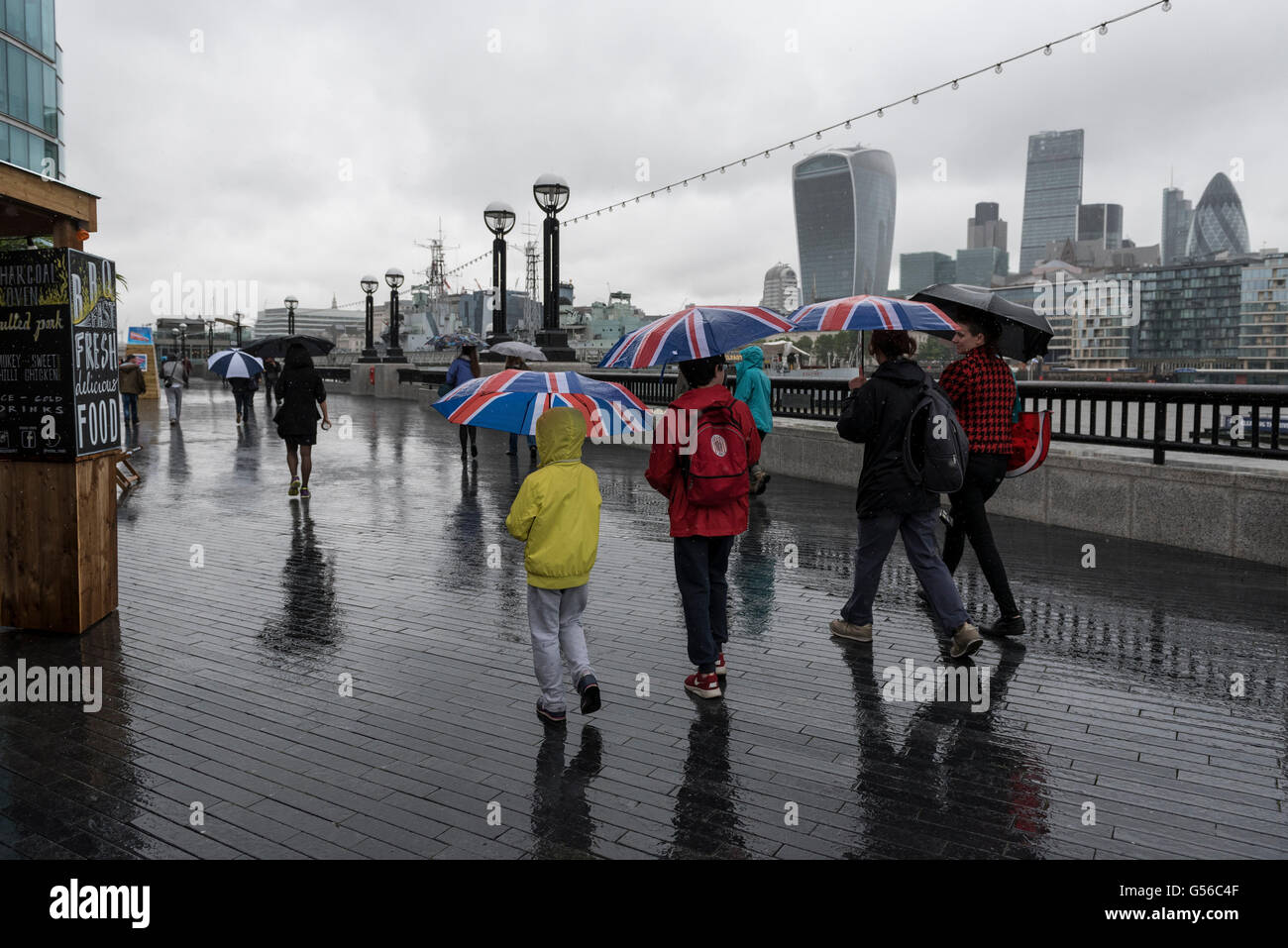 London, UK. 20 June 2016. Tourists walk in the heavy rain pouring down ...
