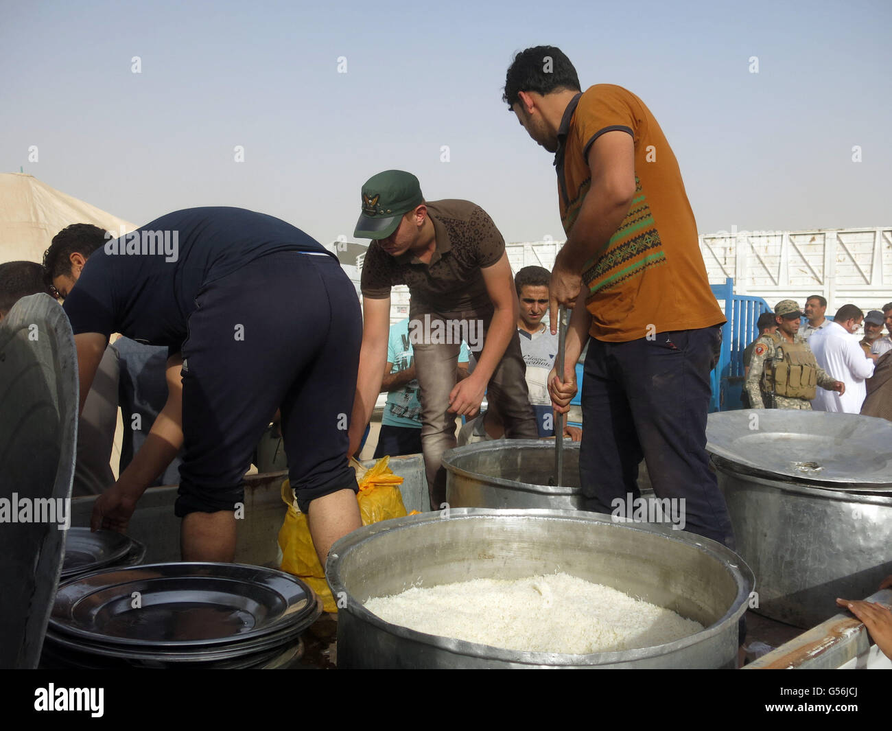 Fallujah, Iraq. 21st June, 2016. People prepare food in a camp for ...