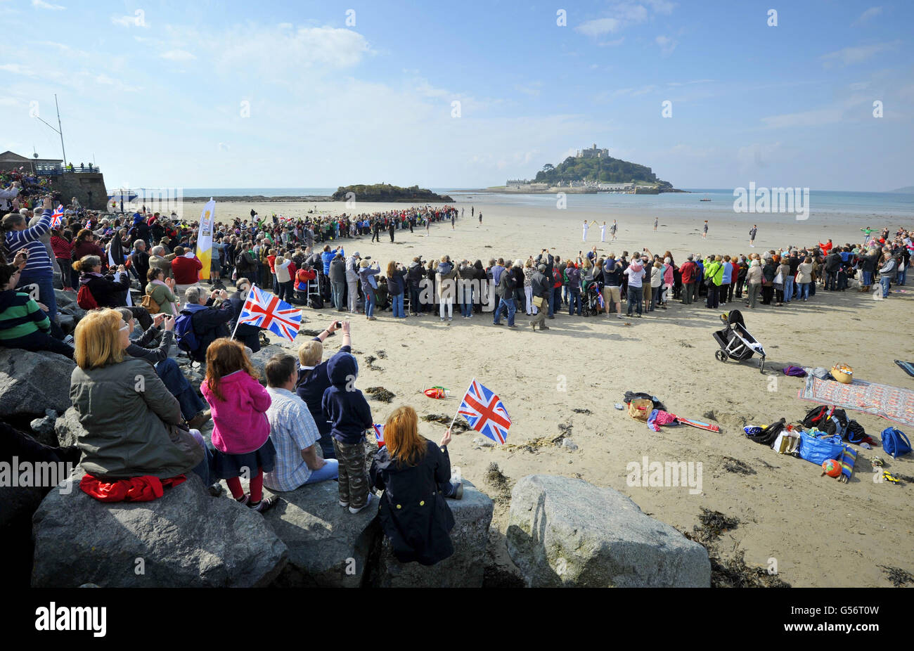 Crowds watch as Sarah Blight passes the Olympic flame to a torchbearer ...