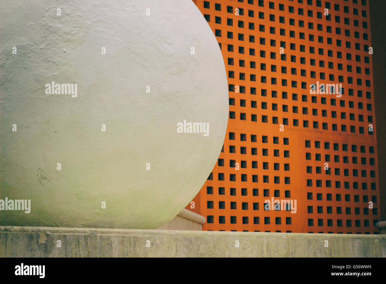 Photograph of a concrete sphere and a wall with a squared geometrical ...