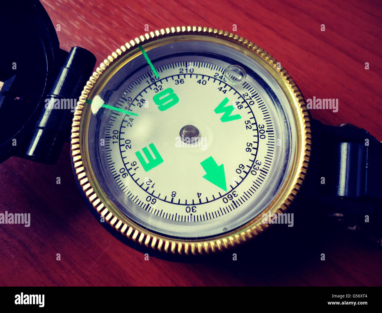 Photograph of a compass on a wood table Stock Photo - Alamy