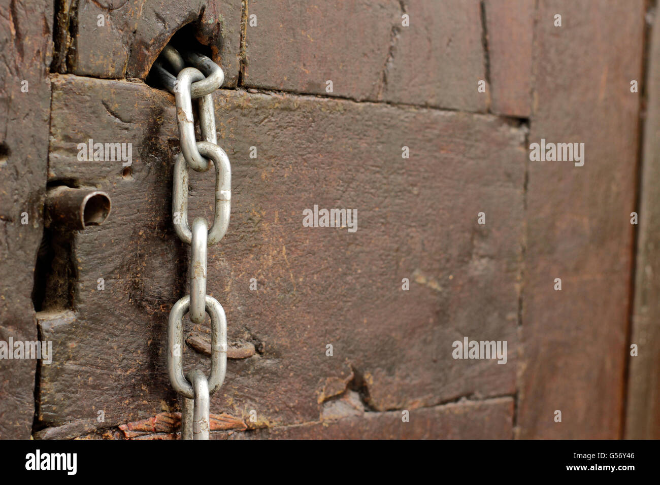 Photograph of a metal chain on wood door Stock Photo - Alamy