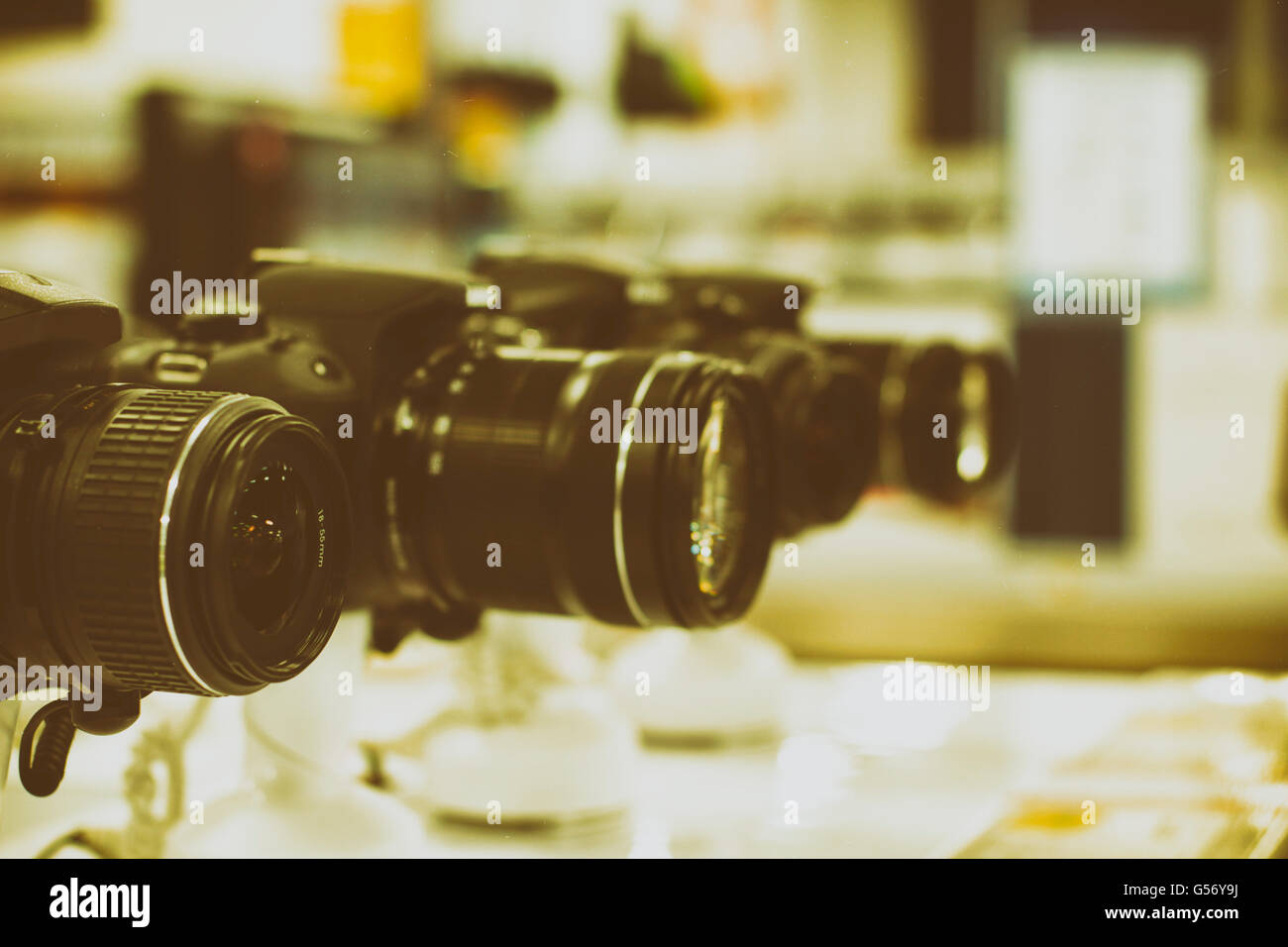 Photograph of some reflex cameras on a counter at a store and a blurred ...