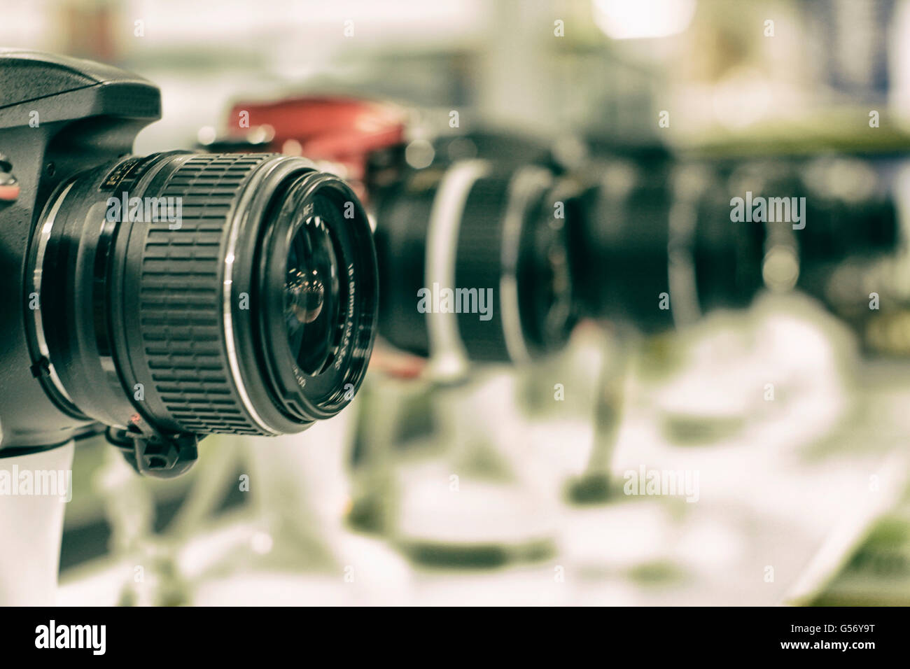 Photograph of some reflex cameras on a counter at a store and a blurred ...