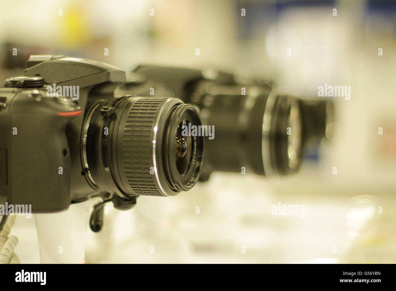 Photograph of some reflex cameras on a counter at a store and a blurred ...
