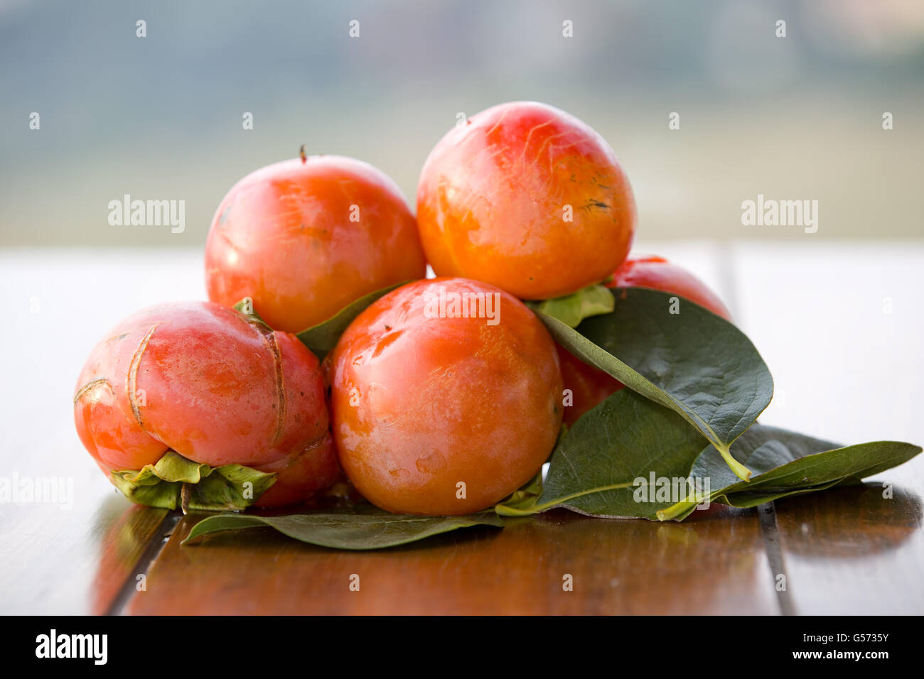 ripe persimmons on a table, outdoor Stock Photo - Alamy