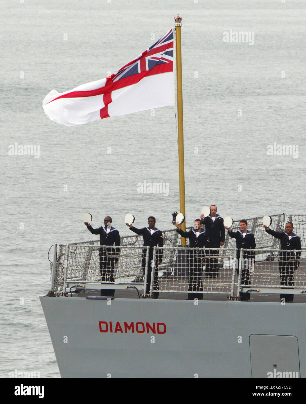 Sailors raise their caps as HMS Diamond enters Portsmouth Harbour after ...