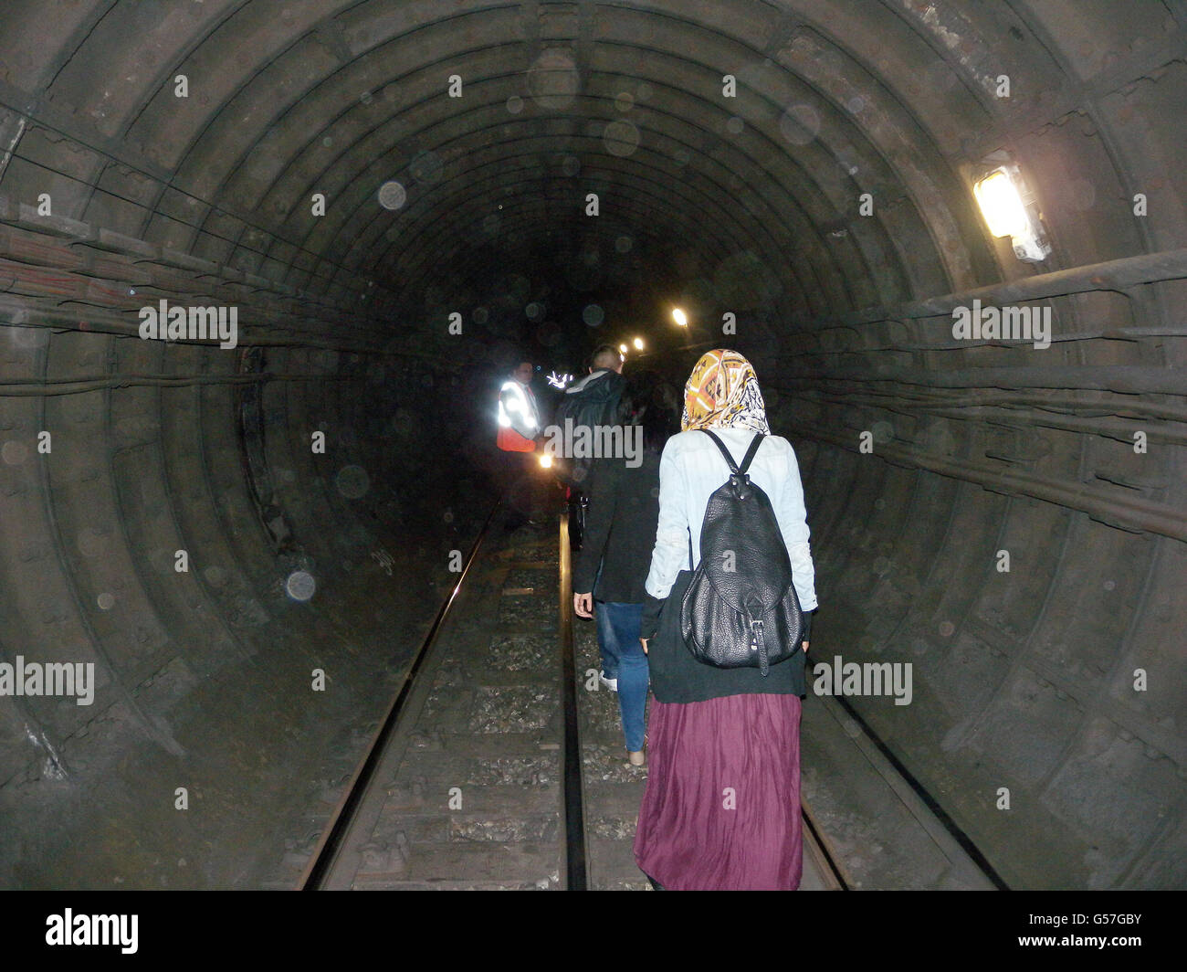 Passengers walk along tube tracks towards Stratford, east London after ...